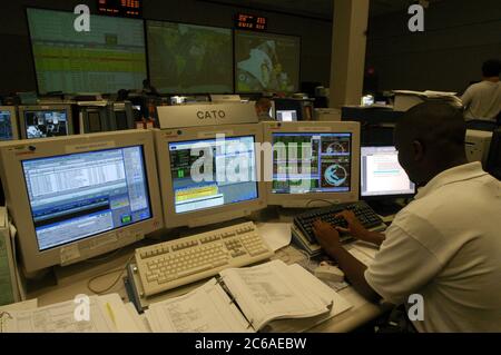 African American flight control employee in headset monitors space ...