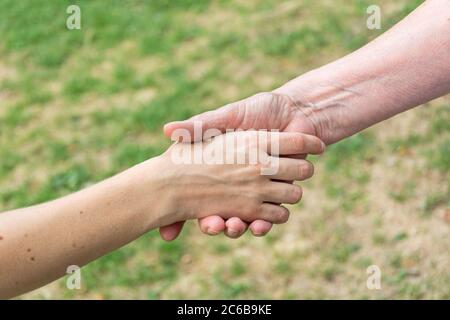 Old and young hands doing handshake Stock Photo - Alamy