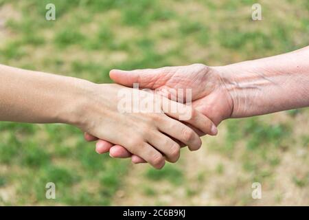 Old and young hands doing handshake Stock Photo - Alamy