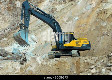 Yellow loader, dredge, big yellow loader carries a large stone in the ...