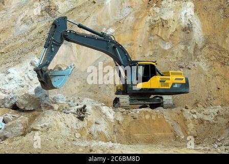 Yellow loader, dredge, big yellow loader carries a large stone in the ...
