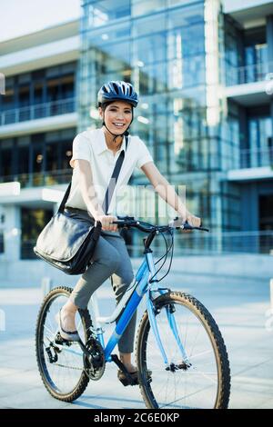 Woman with bicycle on sidewalk by building Stock Photo - Alamy