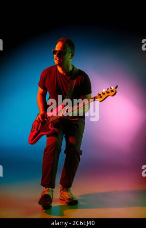 Portrait of an excited man in black clothes showing thumbs up on yellow ...