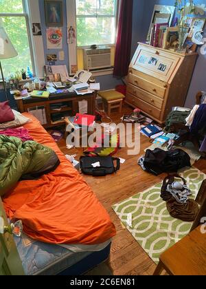 Messy teenager room. Untidy cluttered bed, dirty clothes. Compulsive ...