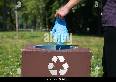 Disposing of used surgical gloves in medical waste bin in hospital ...