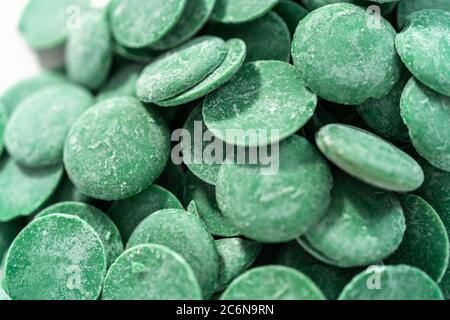 Green round chocolate chips for melting chocolate shapes on a white ...