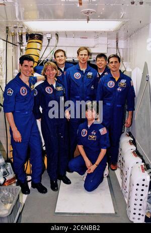 STS-83 Mission Specialist Donald A. Thomas is assisted into his launch/entry suit in the ...