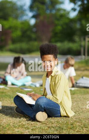 Cute African-American boy with autumn leaves on orange background with ...