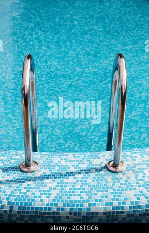 The swimming pool stainless steel handrail descending into tortoise ...