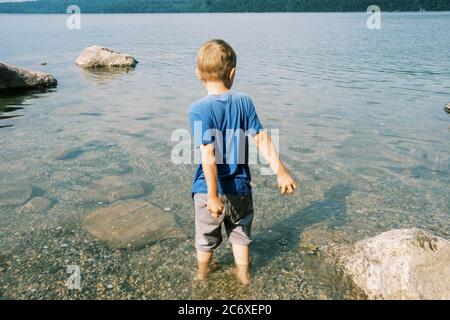 Kids throwing rocks. Two little sibling brothers ans sister playing in ...