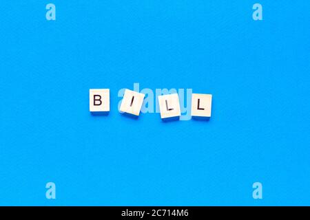 bill in wooden letters on a blue background, flat layout, top view ...