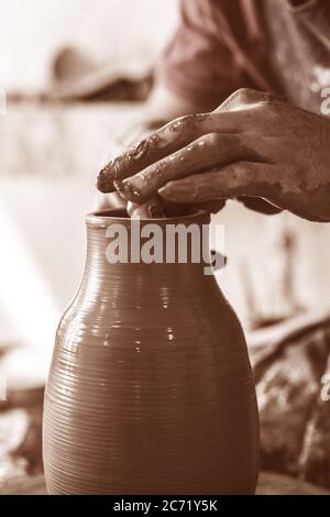 Potter makes clay pot jar on potter's wheel Stock Photo - Alamy
