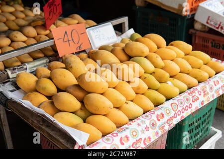 selling fresh mangoes in a market in Asia. Mango is the most popular ...