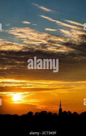 Schellerten, Germany. 14th July, 2020. The sun rises behind the tower ...