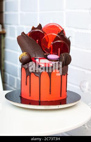 Red cake with chocolate racing car, chocolate decoration, macaroons ...