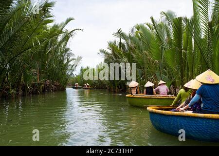 Tourists are enjoying the unique and traditional coracle tour in Bay Mau coconut forest, Vietnam ...
