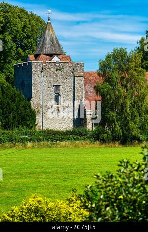 Stone wall of an ancient building in the garden, overgrown with green ...