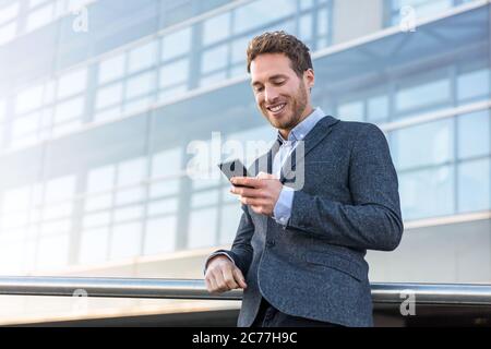 Businessman sms texting or using social media on cell phone in front of ...