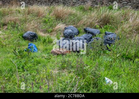 Litter strewn across moor land including worn face masks, toilet paper ...