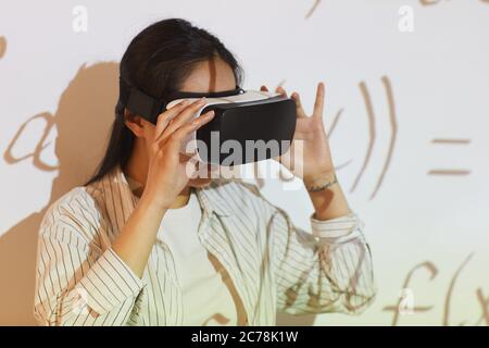 Asian woman using virtual reality headset in modern office for future ...