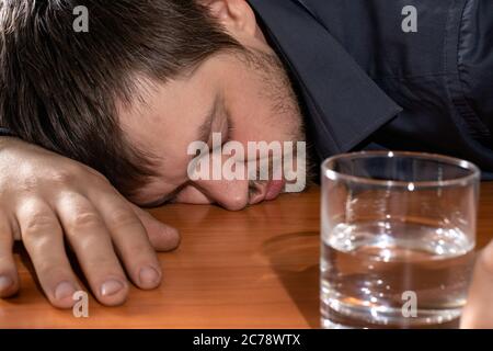 A man in alcoholic intoxication holds a glass of alcohol. Alcoholism ...