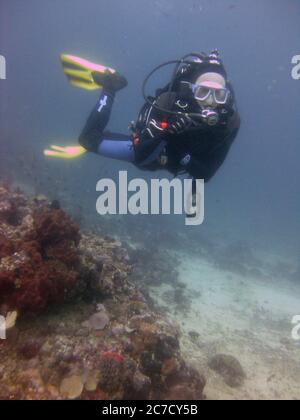Vertical shot of a scuba diver wearing diving suit and equipment ...
