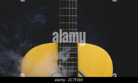 Guitar in smoke close up. acoustic musical instrument. strings on the ...