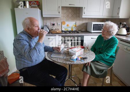 elderly man taking medication and drinking water in living room Stock ...