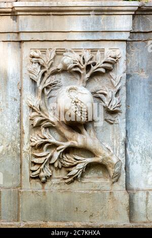 The pomegranate is the symbol of Granada in Spain. Close up of a stone ...