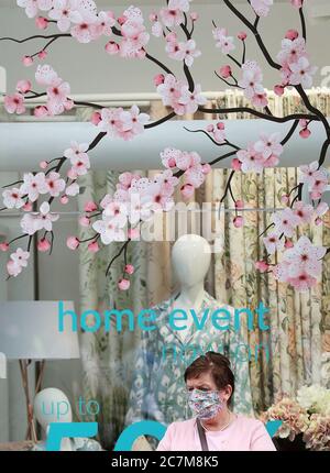 A woman wearing a face mask stands outside a shopping mall in Hong Kong ...