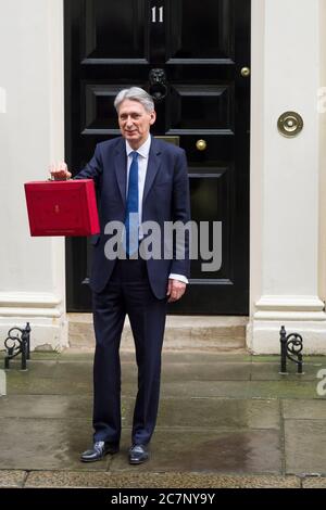 Chancellor of the Exchequer Philip Hammond holds the red case as he ...