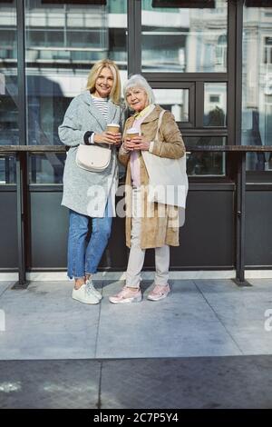 Photo of two joyful beautiful women smiling and holding map while ...