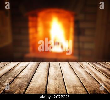 Old wooden table and fireplace with warm fire on the background Stock ...