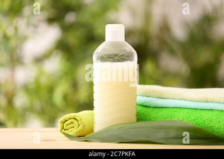 Laundry detergent and towels on table against pink background Stock ...