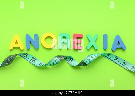 Word ANOREXIA with measuring tape on color wooden background Stock ...