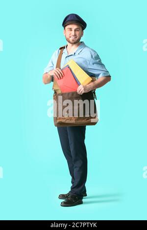Handsome young postman on color background Stock Photo - Alamy