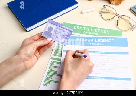 Woman filling in driver license application at table Stock Photo - Alamy