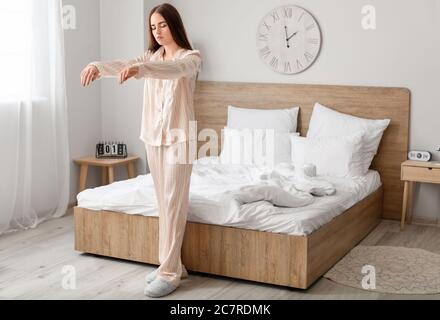young sleepwalking woman in pajamas isolated on white background Stock ...