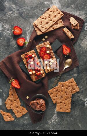 Tasty crispbreads with chocolate and strawberry on dark background ...