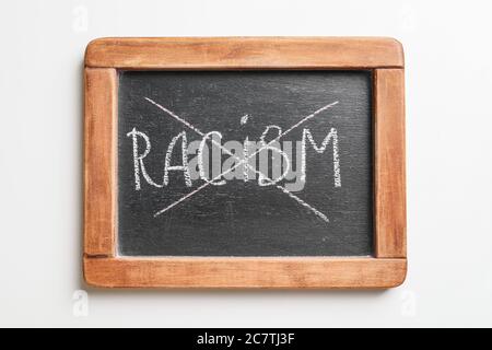 Chalkboard with crossed out word RACISM on white background with space ...