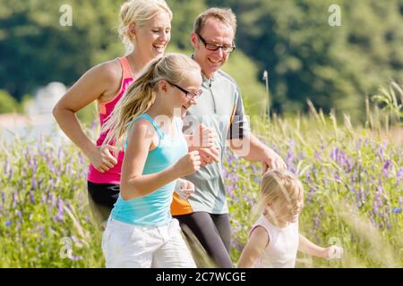 Happy family running through field with kite Stock Photo - Alamy