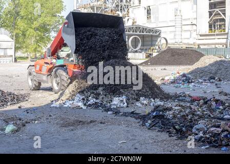 Front loader dumping waste materials at a waste treatment plant Stock ...