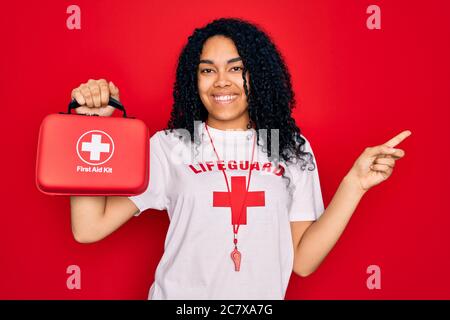 Young african american curly lifeguard woman wearing whistle holding ...