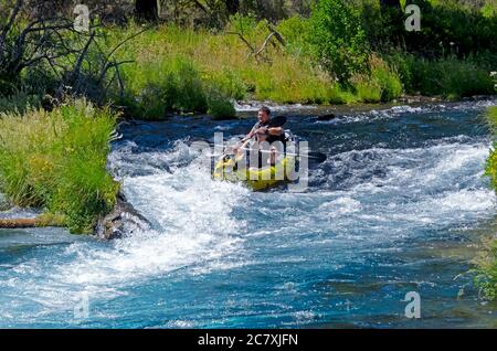 Kayak tipping over while going over the rapids Stock Photo - Alamy