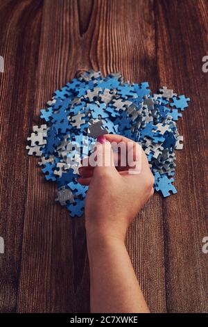 Hand collecting a part of a puzzle Stock Photo - Alamy