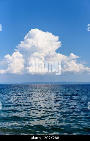 A scenic landscape of a clean blue sea with mountains in the background ...