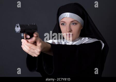 young woman nun shooting with gun isolated on white background Stock ...