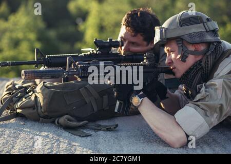 Side view on Soldiers Lie Down on the Hill, Aiming through the Assault ...