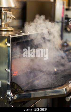 Stylish master chief male with tattoo on his arm grilling a beef in a ...