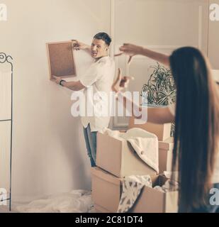 young couple arranging things in their new apartment Stock Photo - Alamy